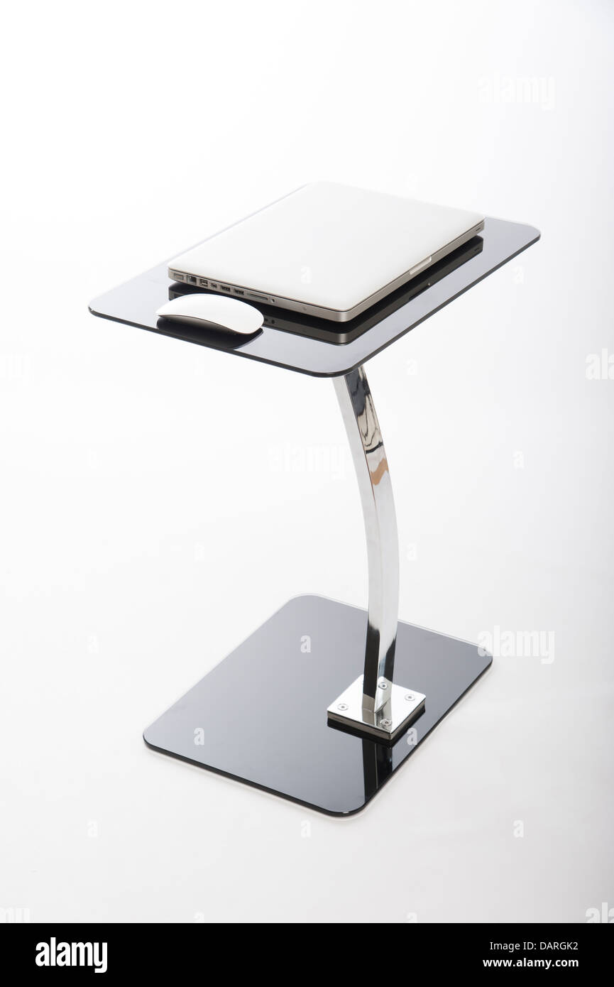 Laptop computer and mouse standing on a glass table Stock Photo - Alamy