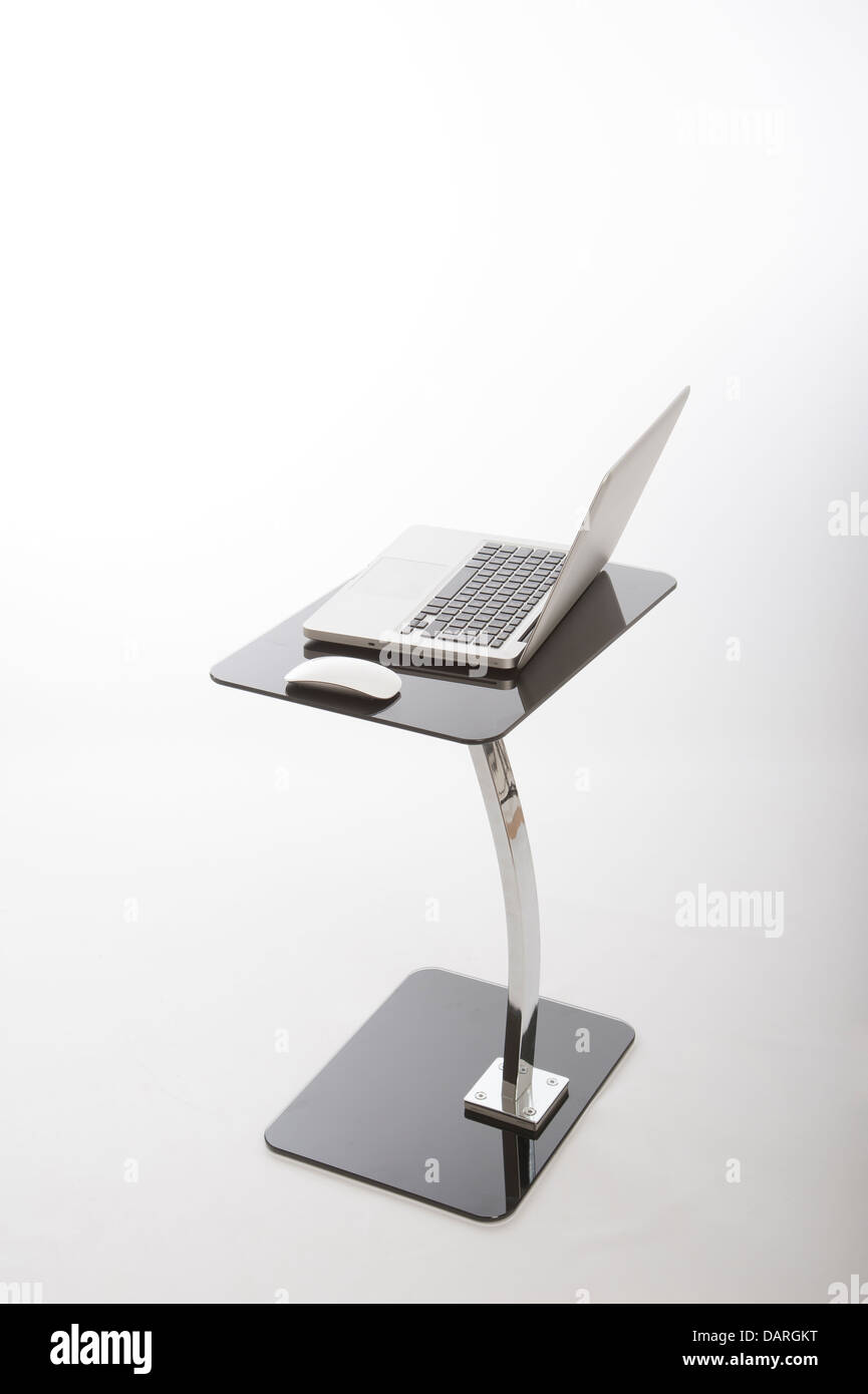 Laptop computer and mouse standing on a glass table Stock Photo - Alamy