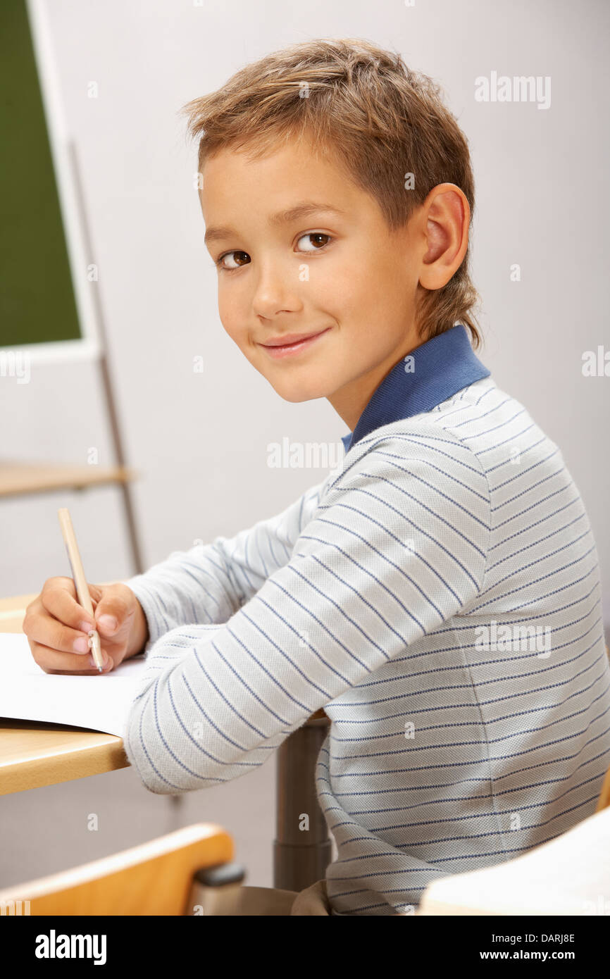 Portrait of smart lad at his place looking at camera during lesson ...