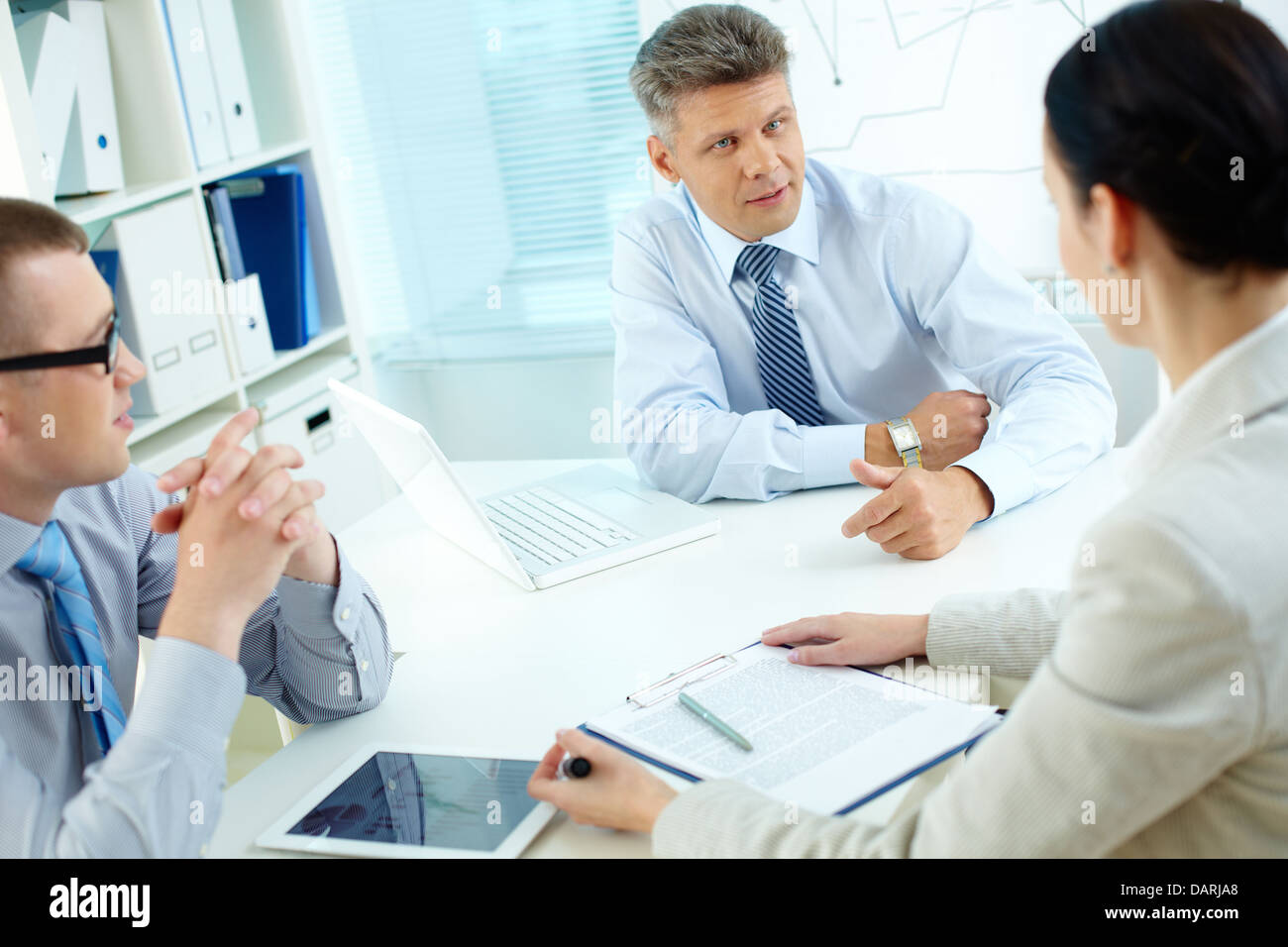 Businessman looking at his employee while explaining his idea Stock ...