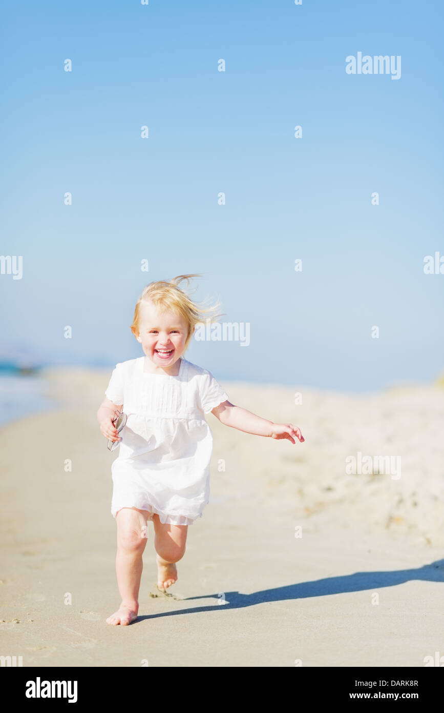 Happy baby running on beach Stock Photo - Alamy