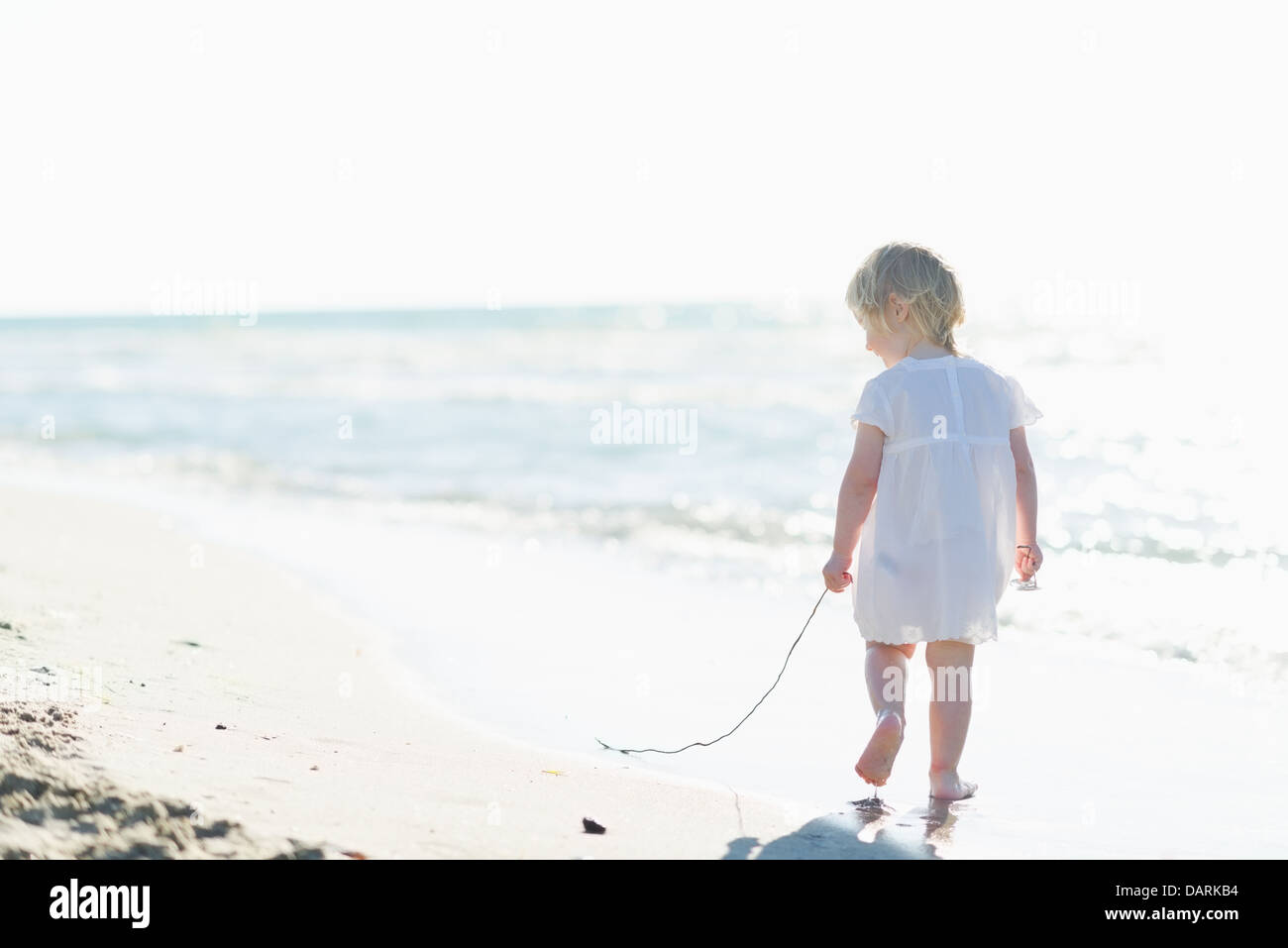 Lonely baby walking at seaside . rear view Stock Photo - Alamy