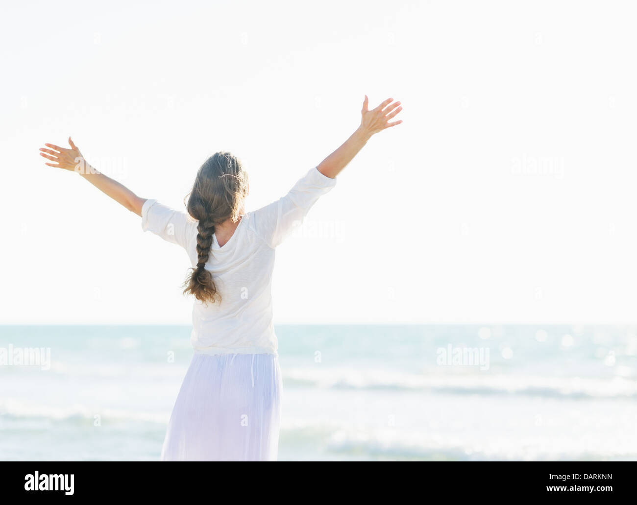 Happy young woman rejoicing at seaside . rear view Stock Photo - Alamy
