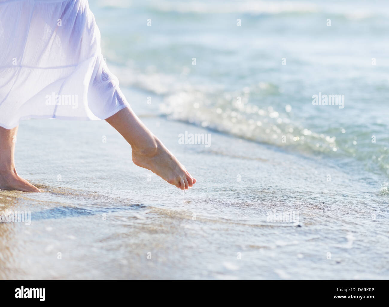 Closeup on leg of young woman standing on sea shore Stock Photo - Alamy