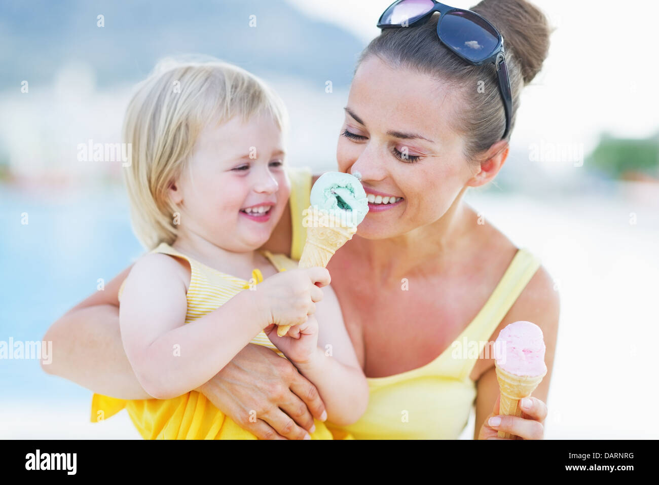 Smiling baby giving mother ice cream Stock Photo - Alamy