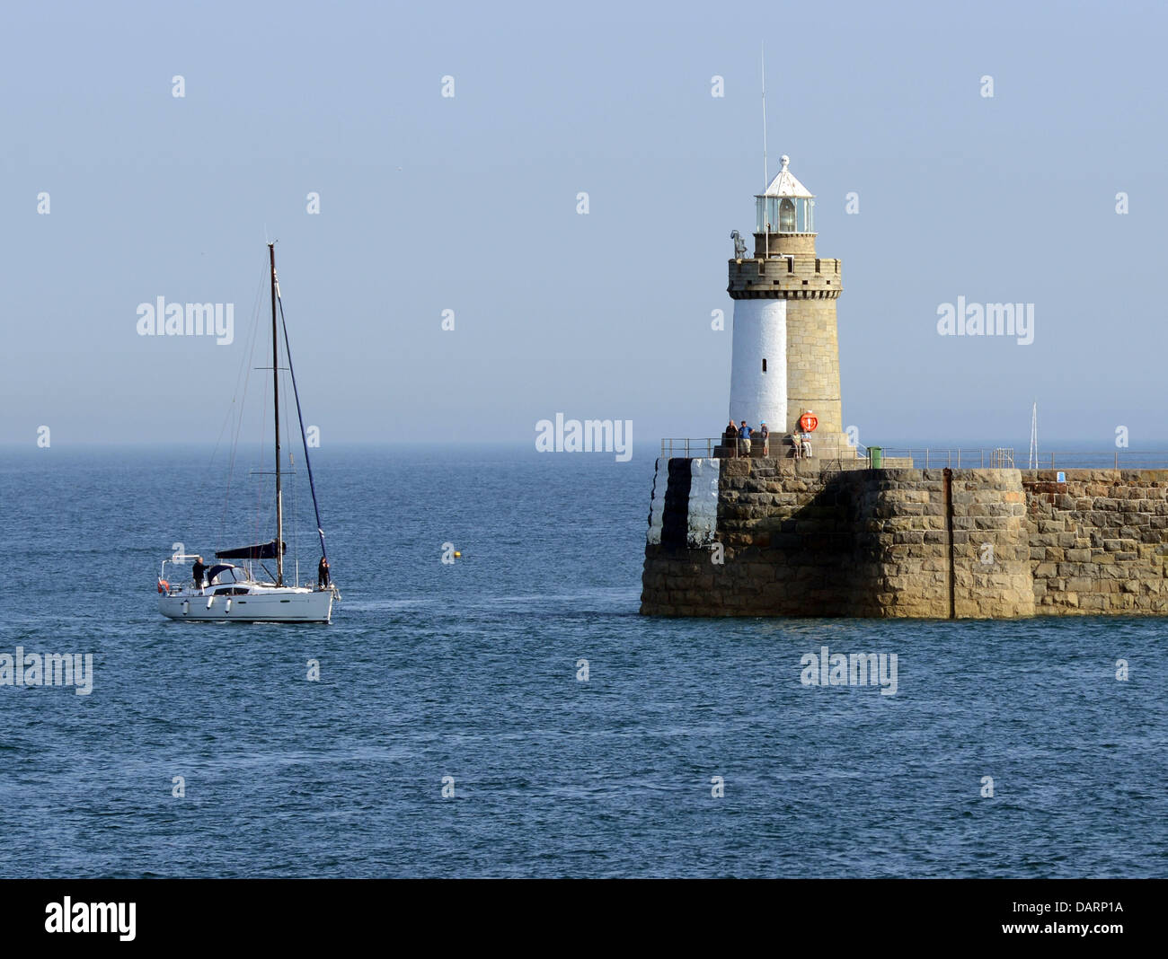 Guernsey, Lighthouse and yacht at the entrance to St Peter Port harbour ...