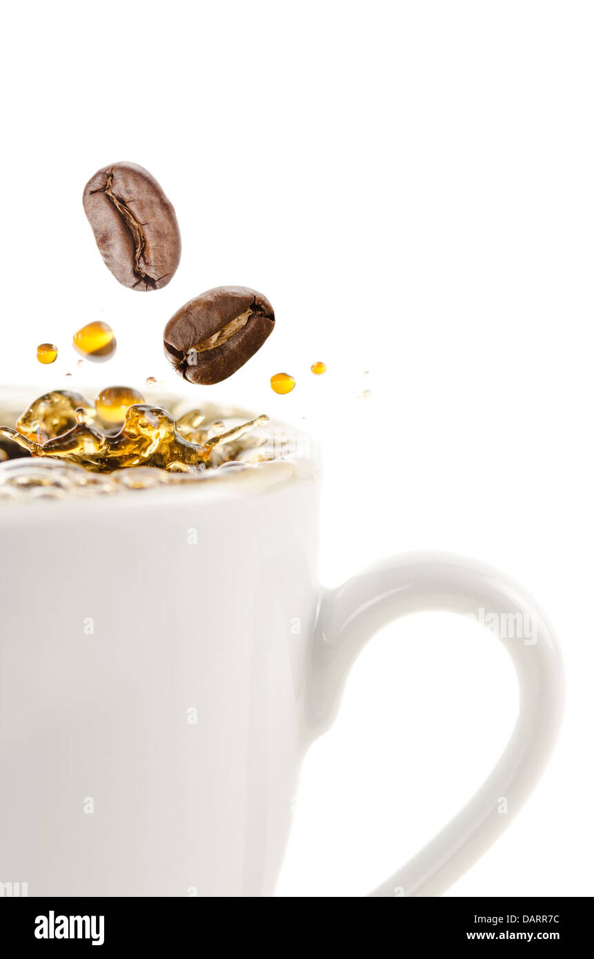 Coffee beans fall in a cup full with coffee Stock Photo - Alamy