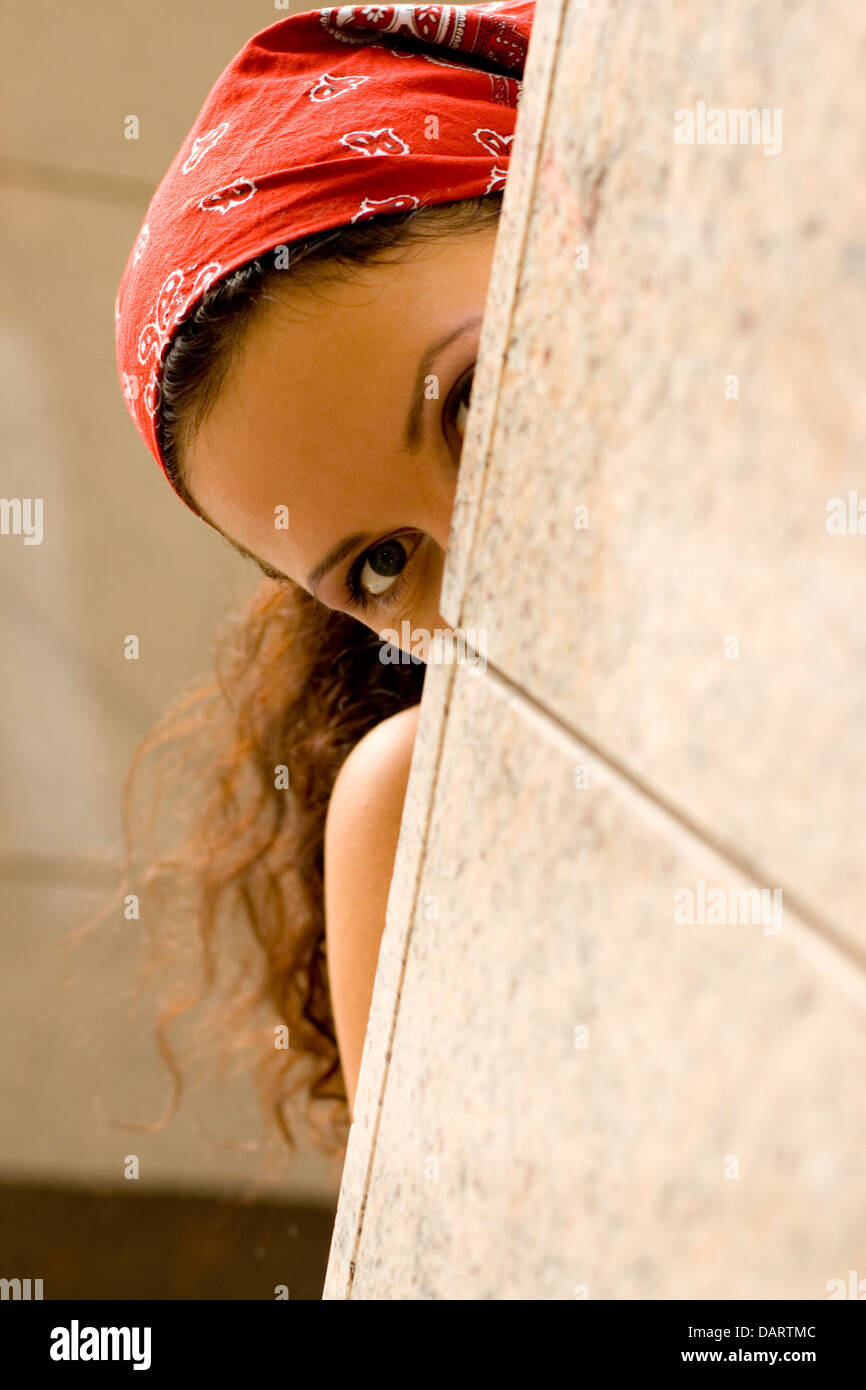 woman looking behind a wal Stock Photo - Alamy