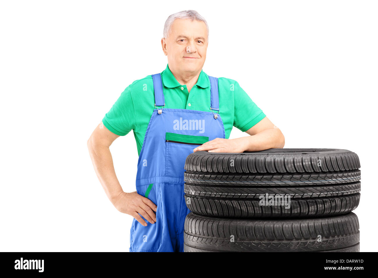 Smiling mature worker posing on car tires Stock Photo - Alamy