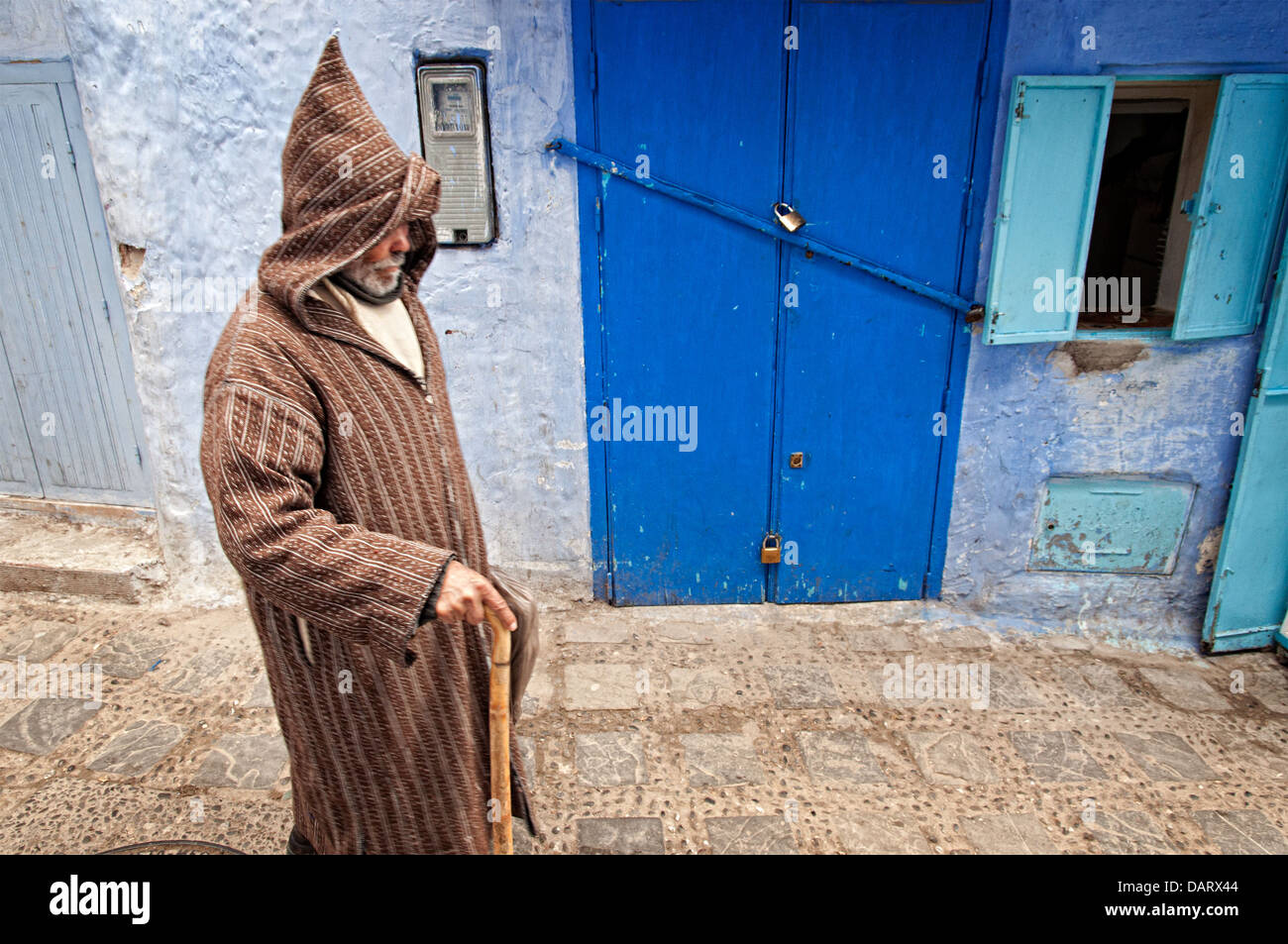 Man wearing traditional djellaba and walking by the streets of the ...