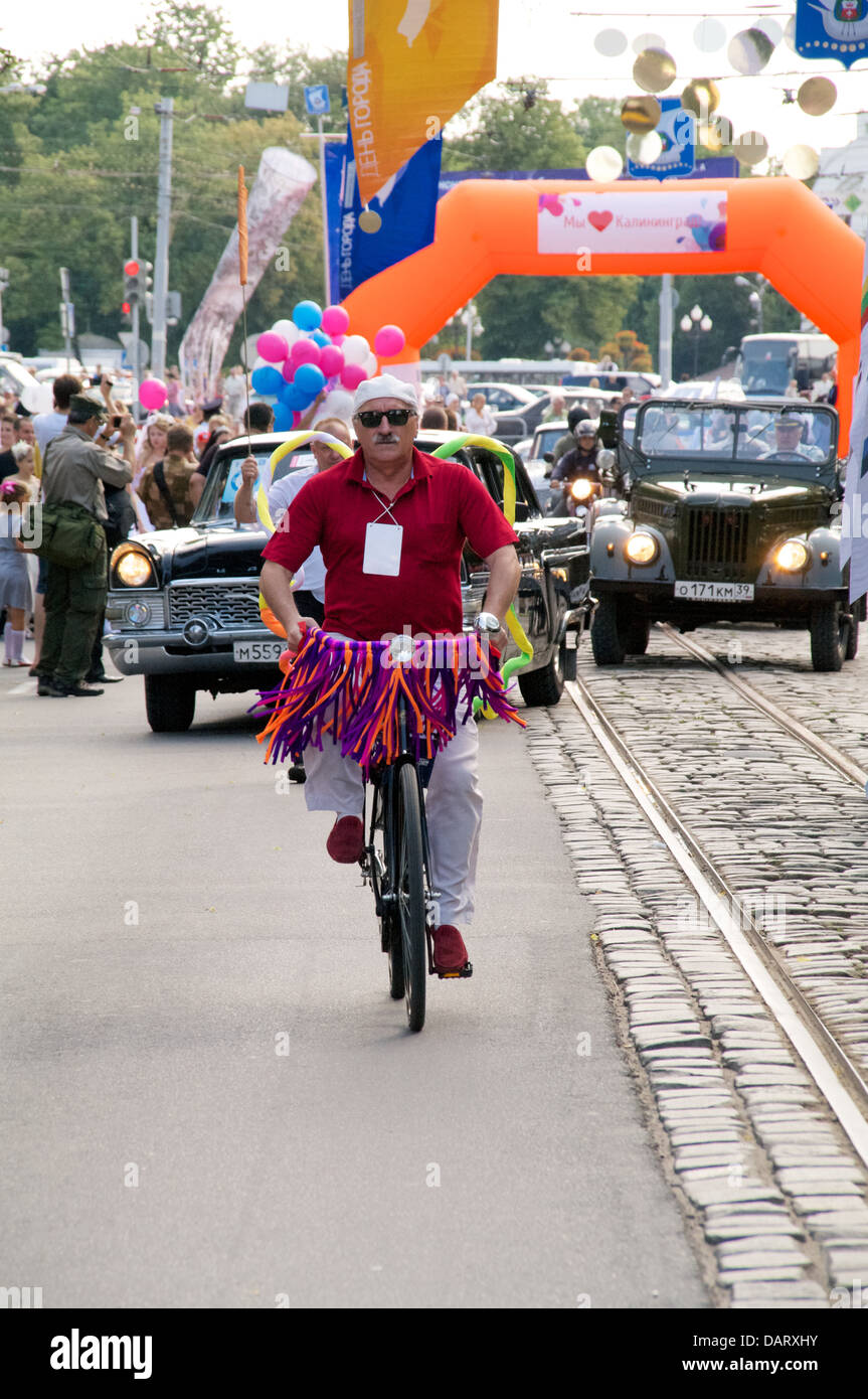 cyclist moves ahead of retro cars parade Stock Photo - Alamy