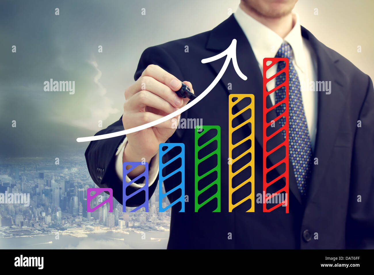 Businessman drawing a rising arrow over a bar graph above the city ...