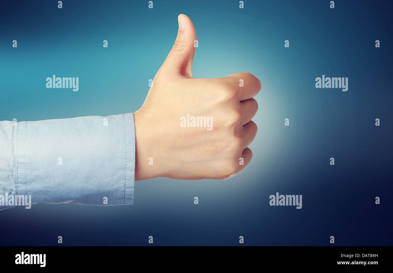 Person giving the thumbs up over blue background Stock Photo - Alamy