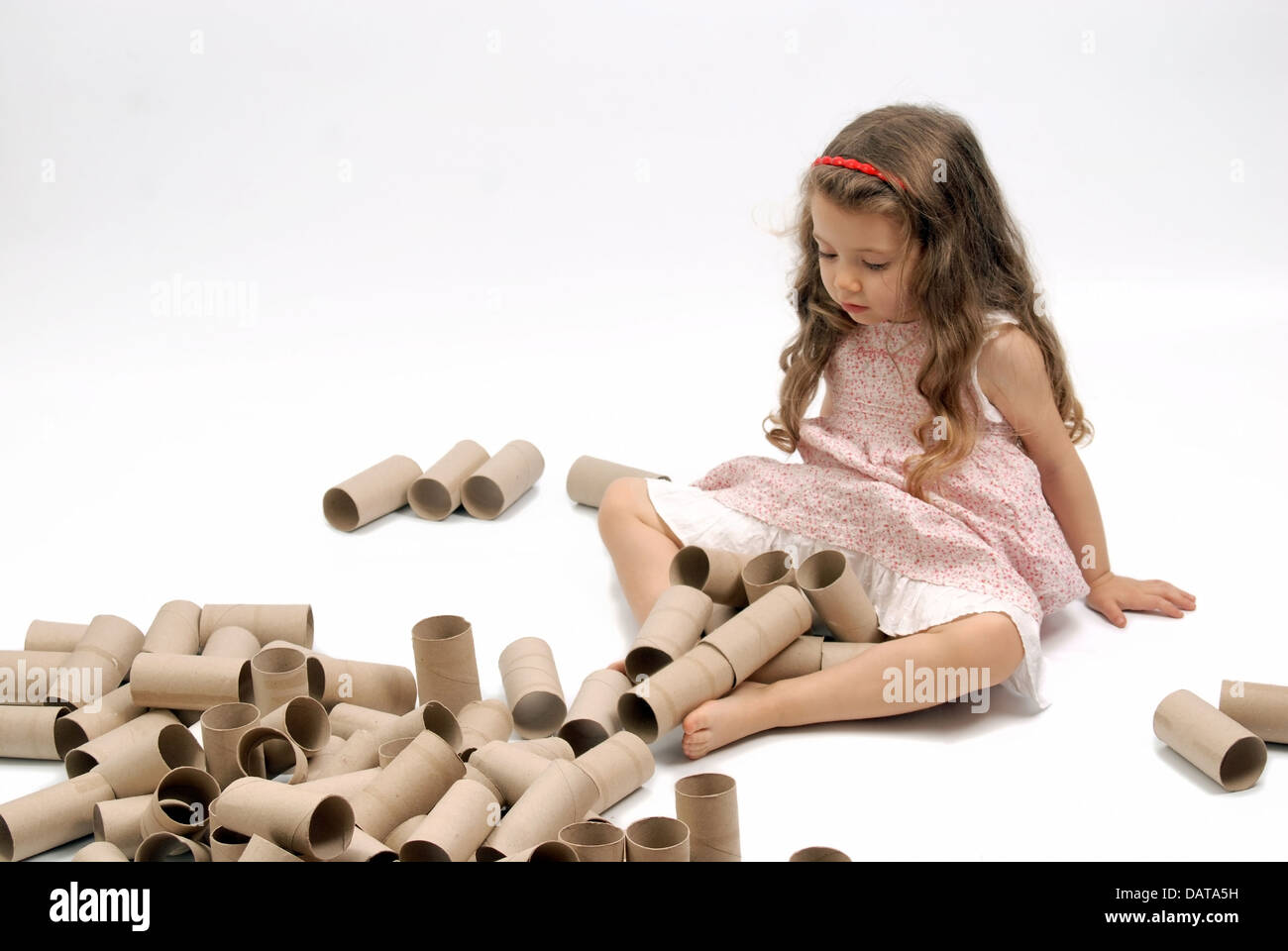 Girl playing with paper rolls tower Stock Photo - Alamy