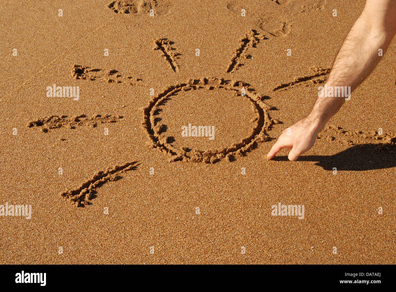 hand drawing a sun in the sand Stock Photo - Alamy