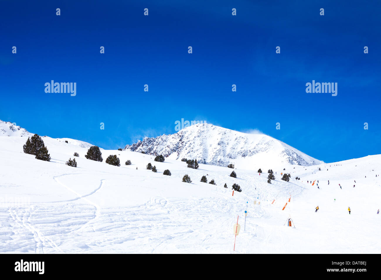 Slope for skiing in mountains with marked pistes and peak covered in ...