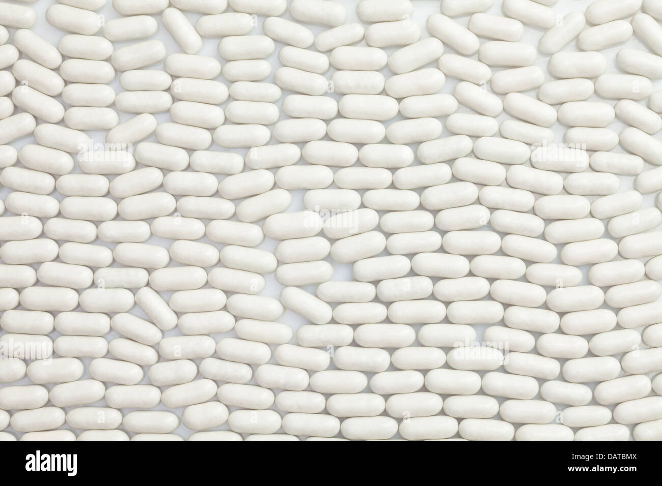 Many same white pills in a row pattern Stock Photo - Alamy