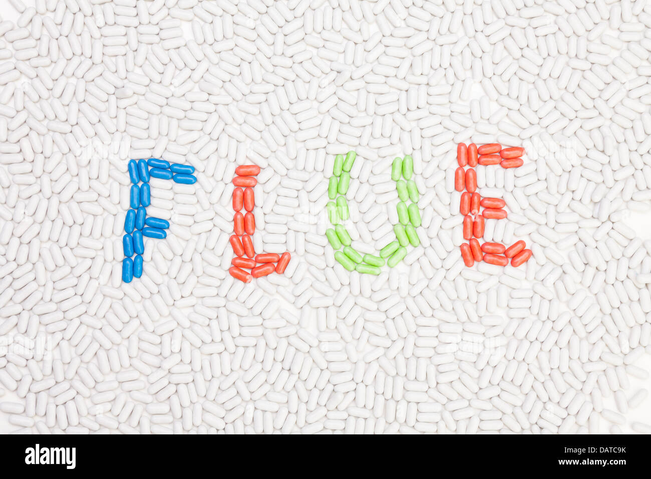 Flue word text made of tablets and pills drugs of different colors put ...