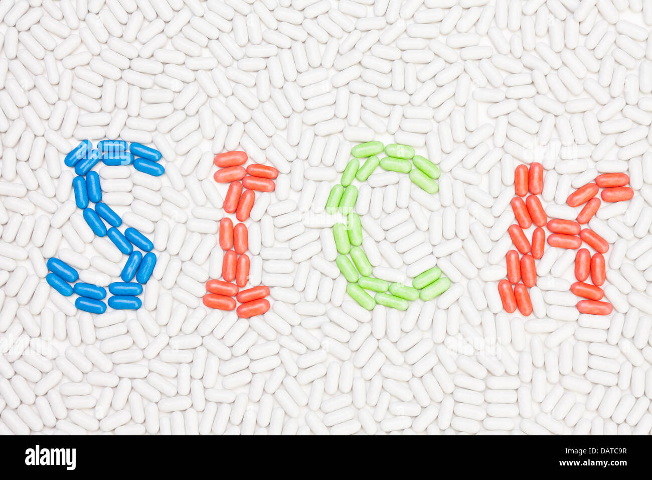 Sick word text made of tablets and pills drugs of different colors put ...