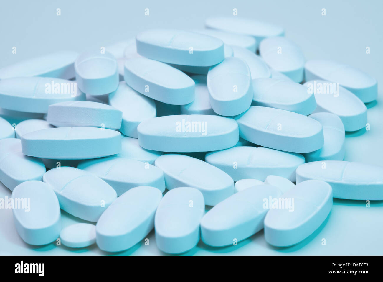 Pile of prolonged white tablets drugs laying in group Stock Photo - Alamy