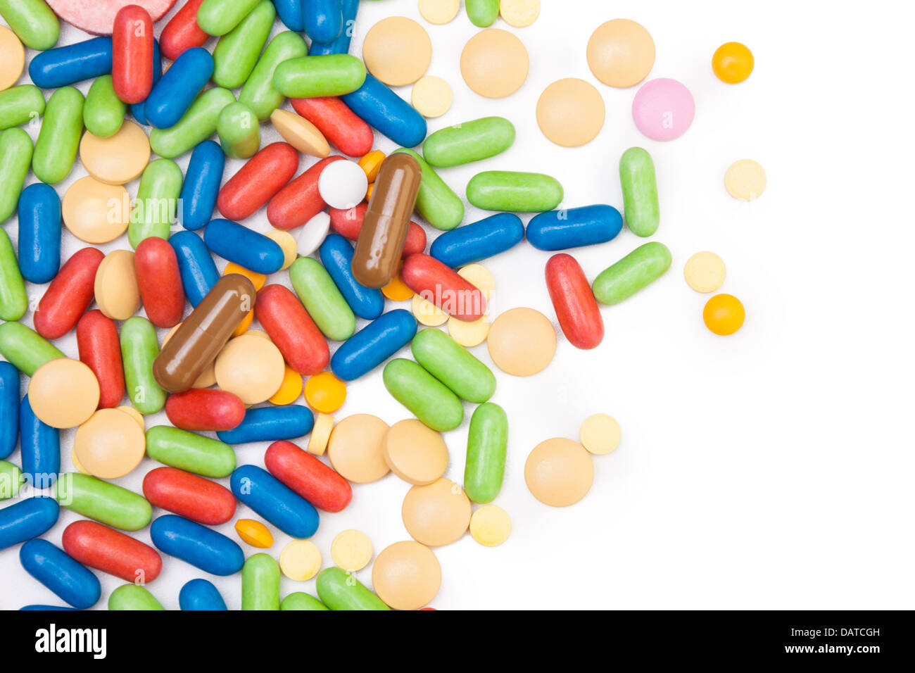 Pile of drugs and tablets of different color laying on white table ...
