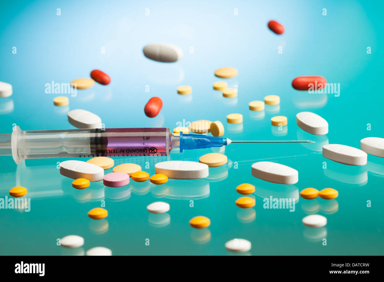 Many different drugs pills and tablets on the table with syringe with ...