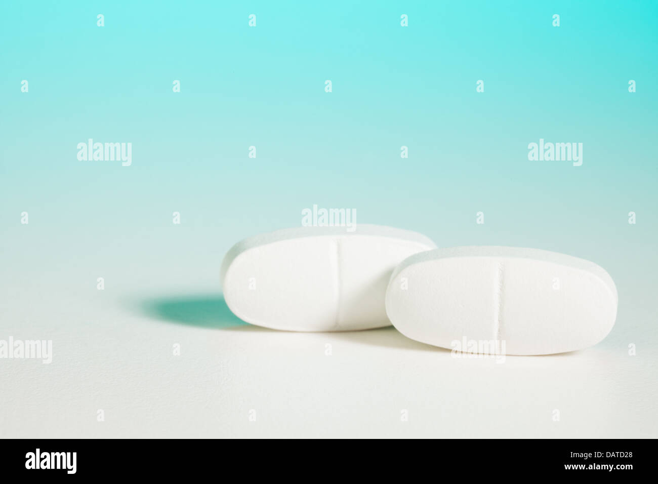 Close-up of two big tablets drugs on white table Stock Photo - Alamy