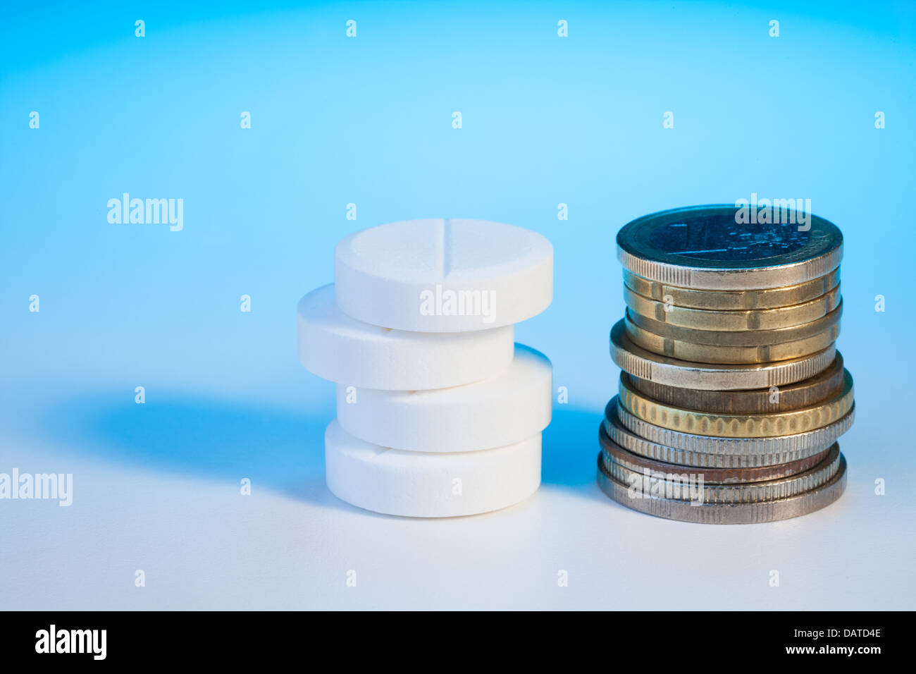 Pie of big circle tablets drugs on blue table and stack of different ...
