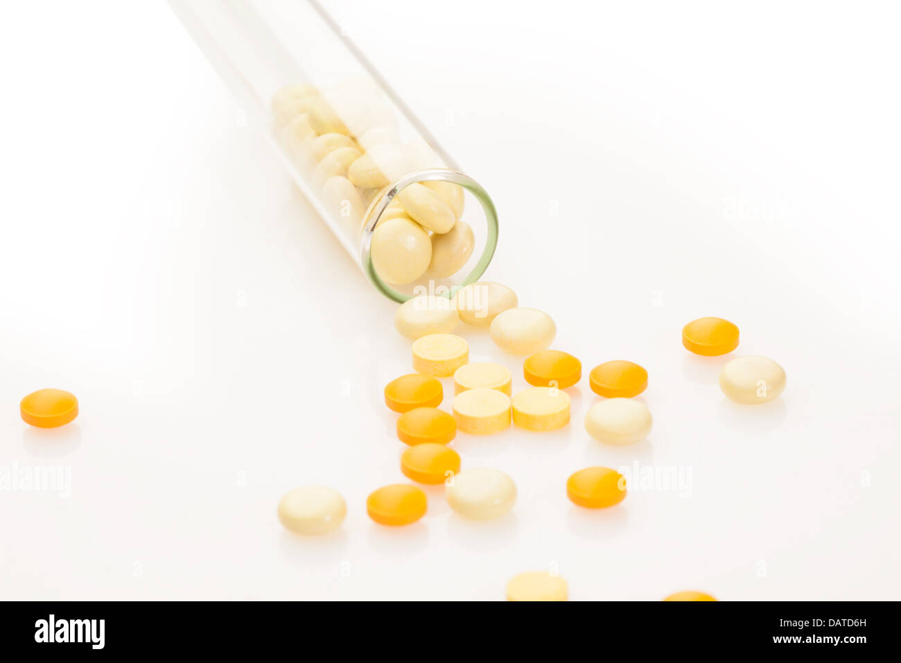 many color drags in tablets scattered from lab test tube depicting ...
