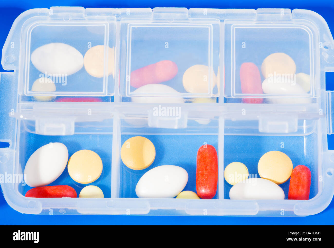 Close-up of open dosage plastic container full of different color drugs ...