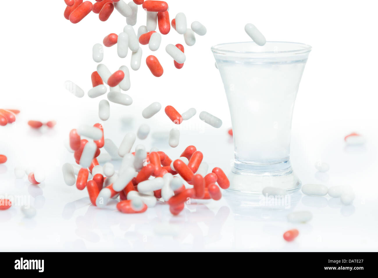 Many different drugs, pills and tablets falling on the table, red and ...