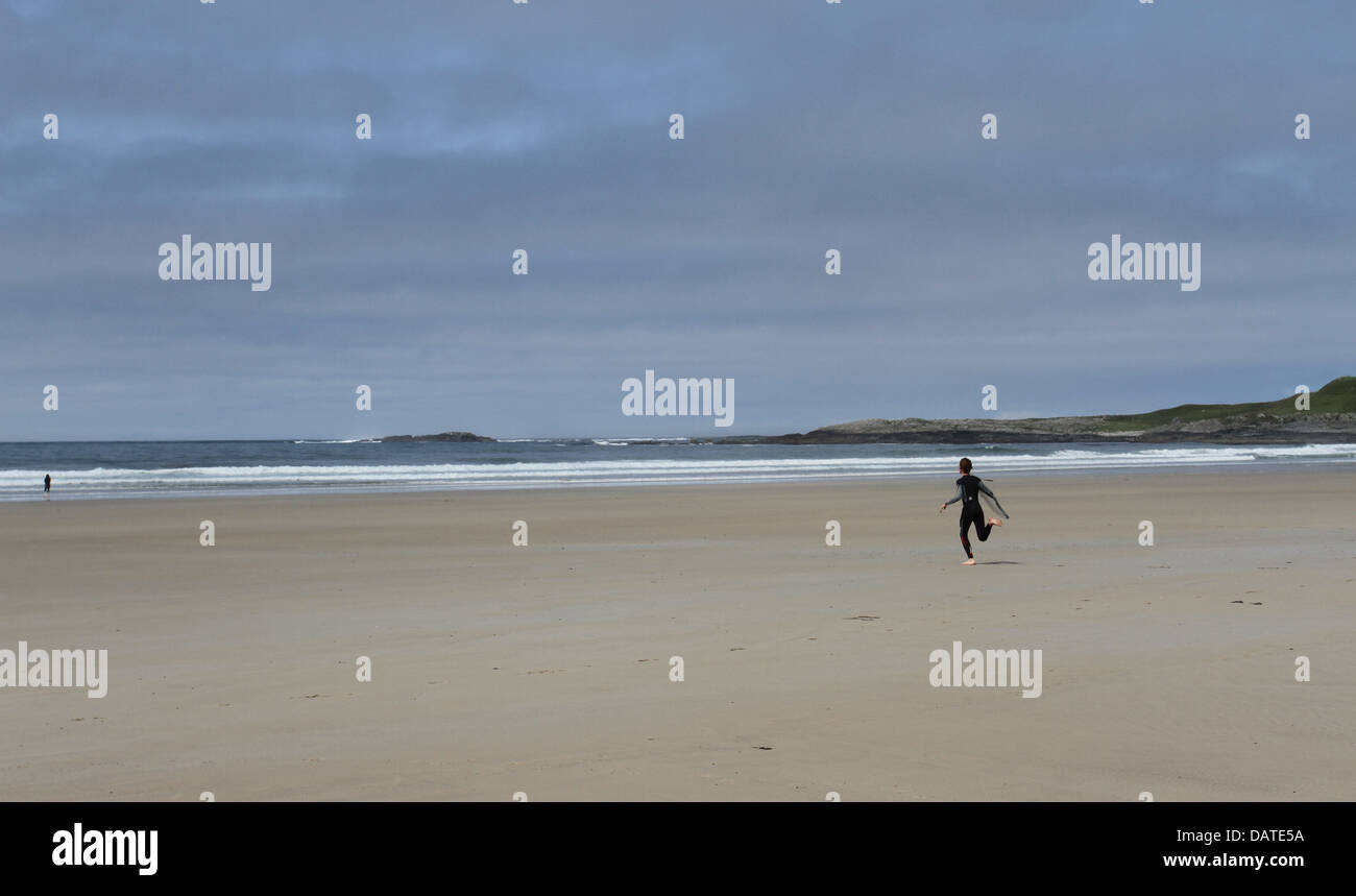 Boy with bodyboard running towards sea Machir bay Isle of Islay ...