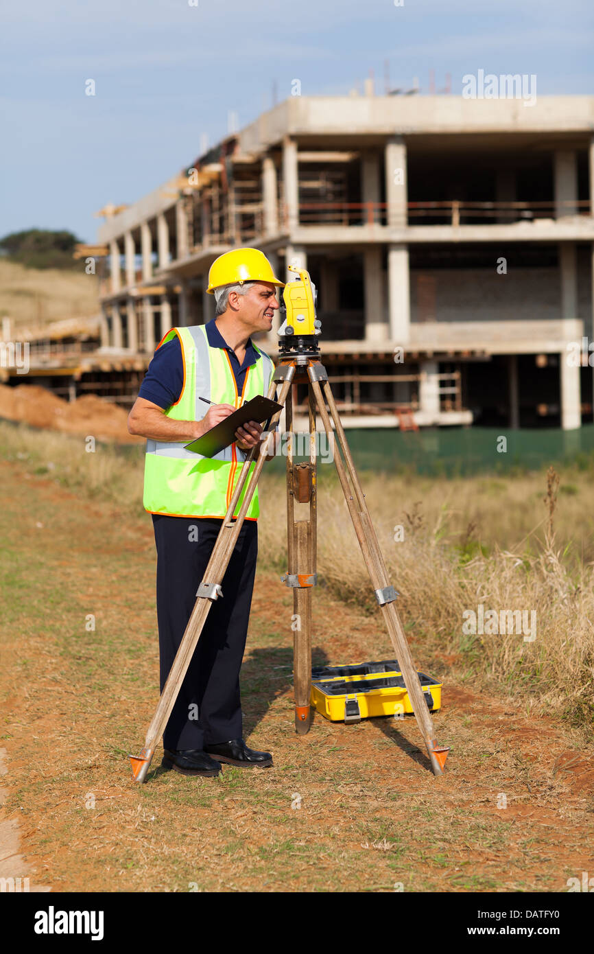 middle aged land surveyor working at construction site Stock Photo - Alamy