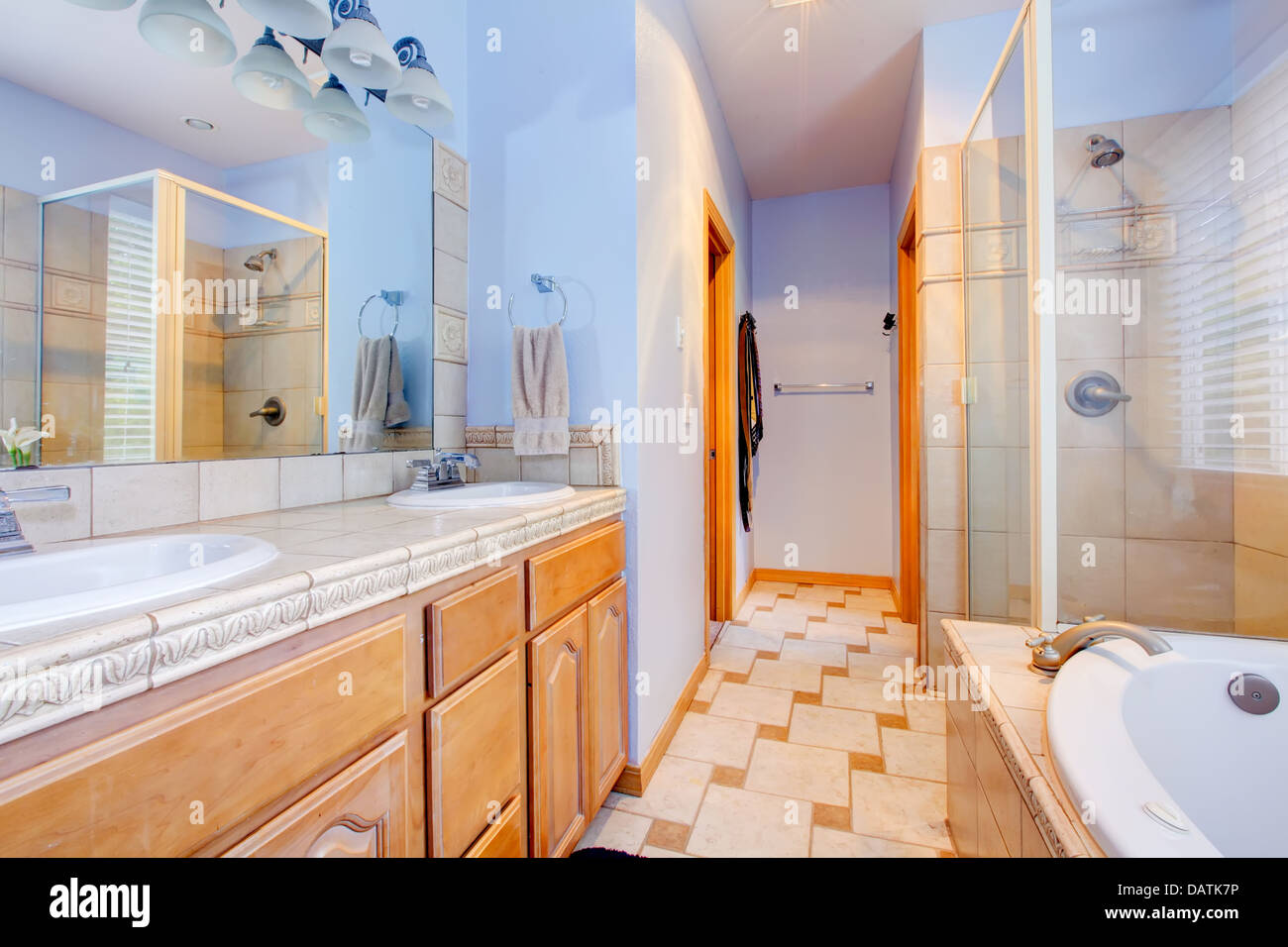 Blue large bathroom with tub and shower Stock Photo - Alamy