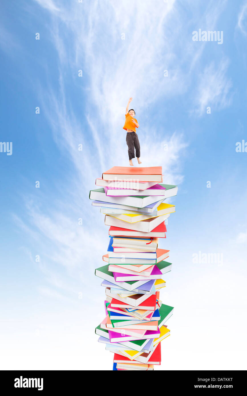 happy kid jumping on the books Stock Photo - Alamy