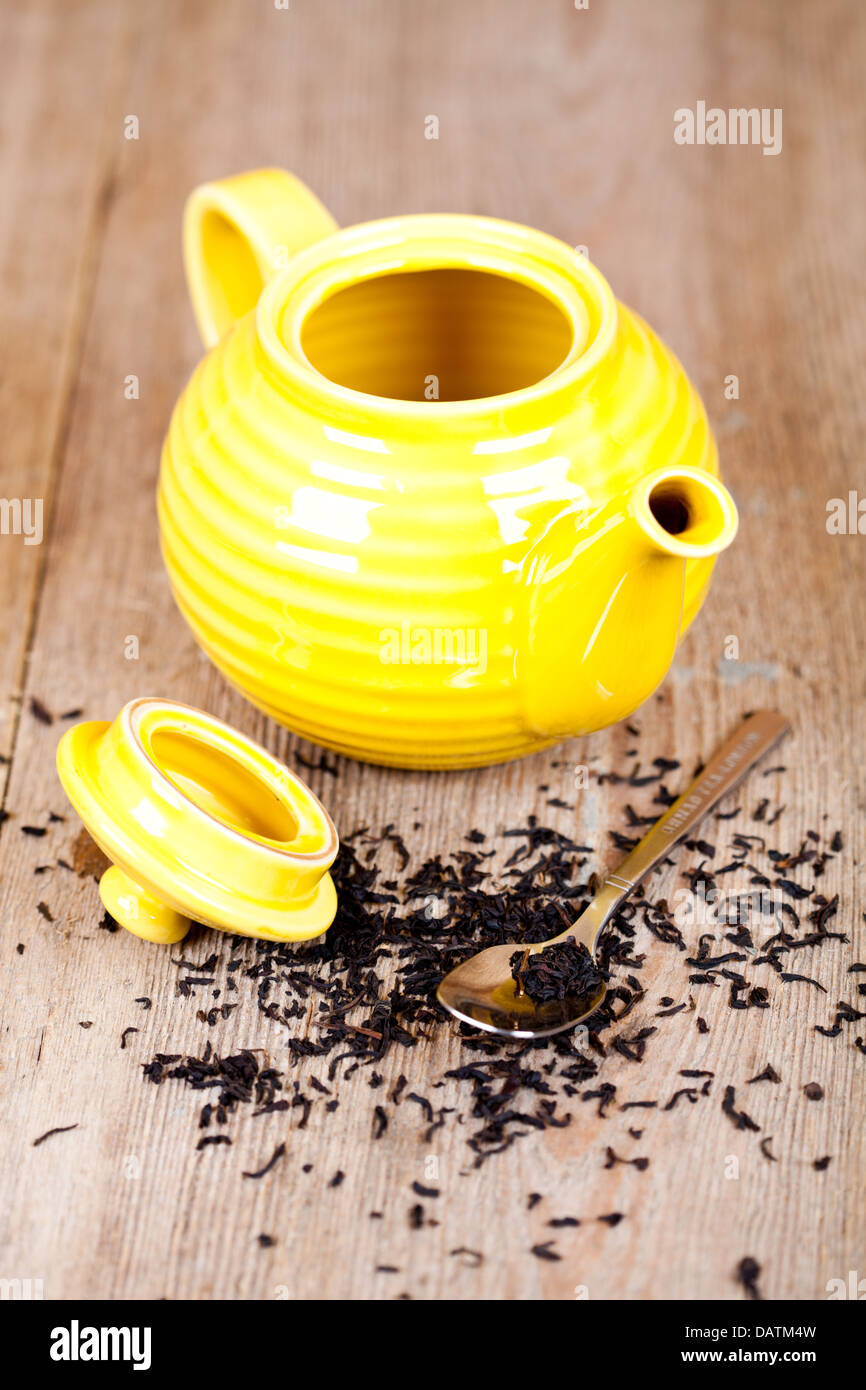 yellow teapot with spoon and tea Stock Photo - Alamy
