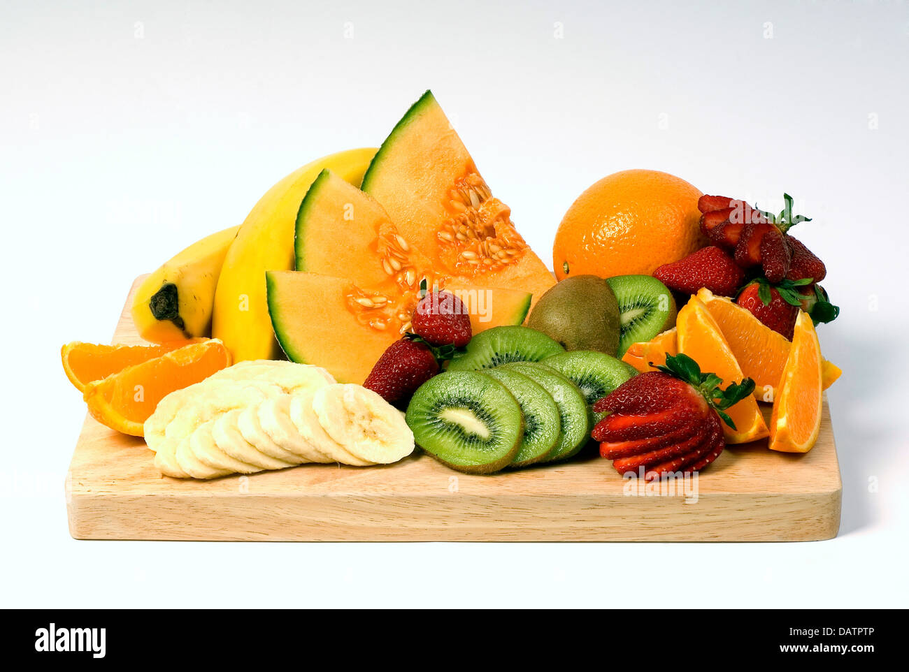 A chopping board full of fresh sliced fruit, including strawberries ...