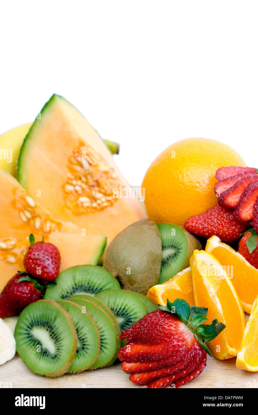 A chopping board full of fresh sliced fruit, including strawberries ...