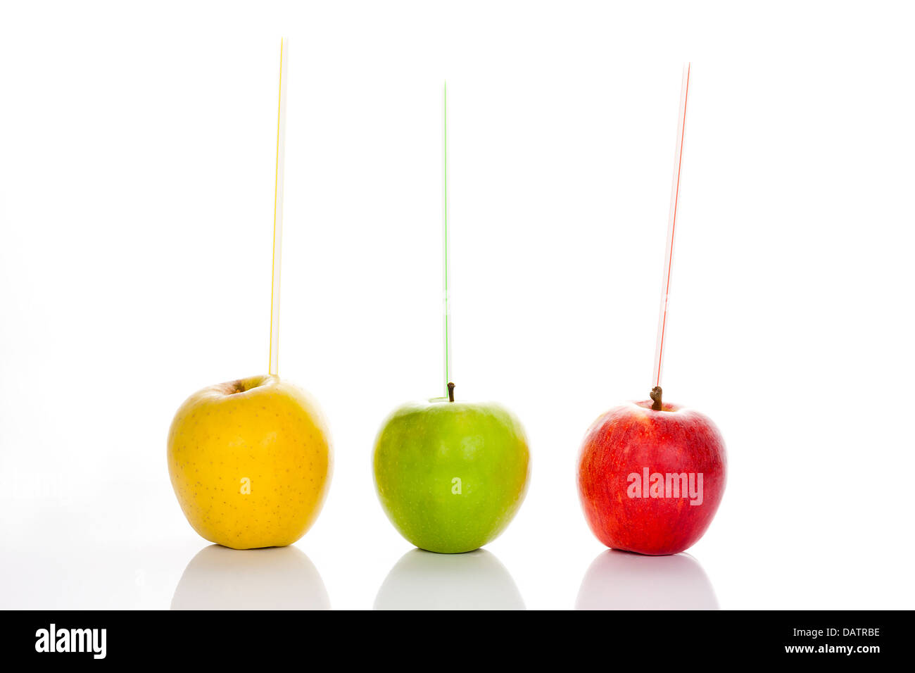 red, yellow and green apples with straws on white background Stock ...