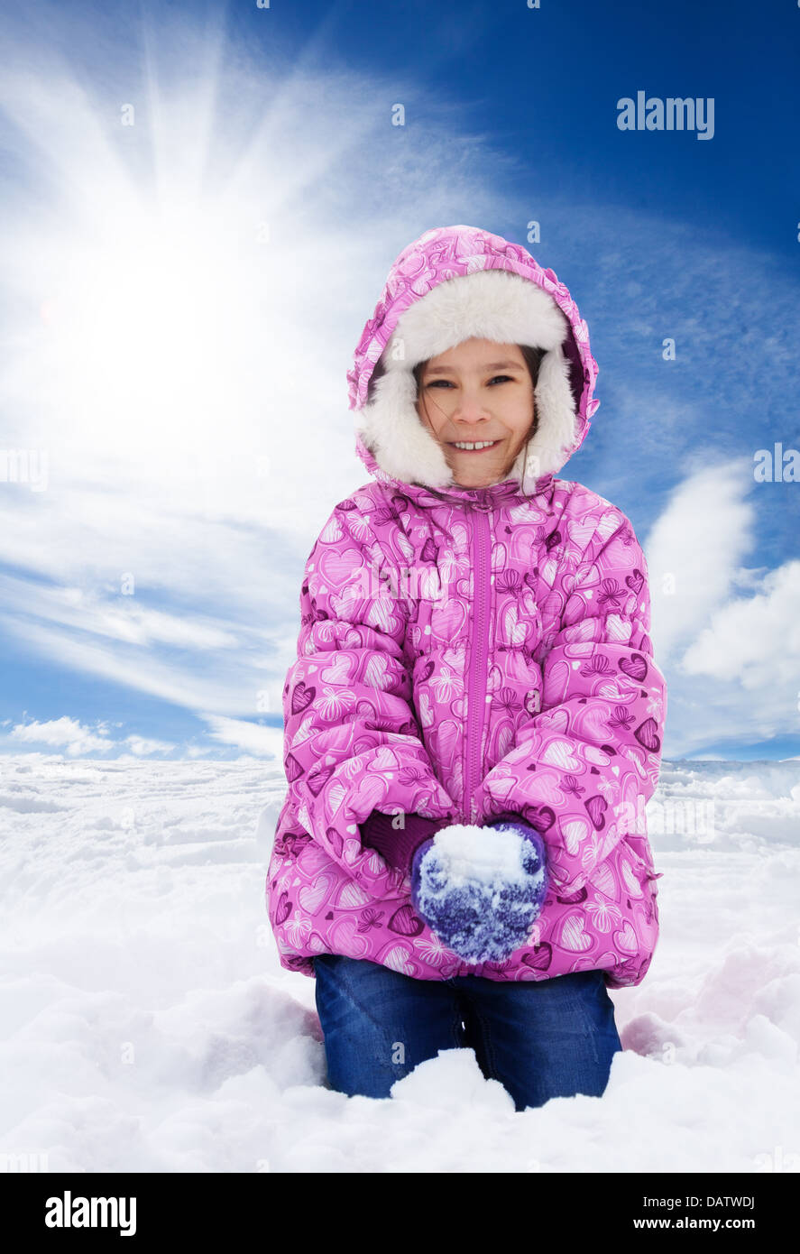 Little happy smiling girl about to throw snowball in the air on winter ...