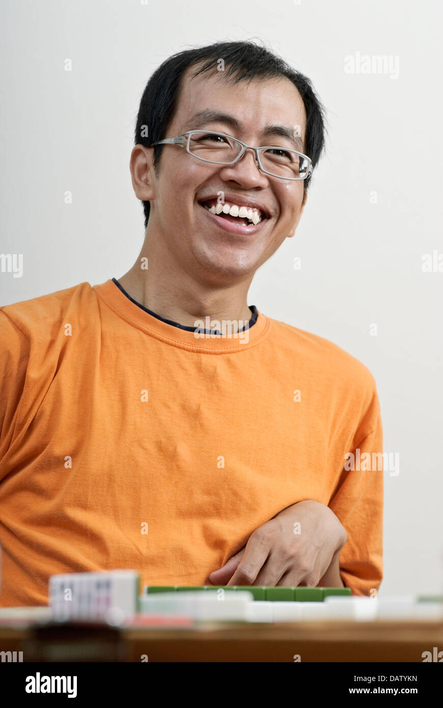 Happy smiling Asian man play Mahjong Stock Photo - Alamy