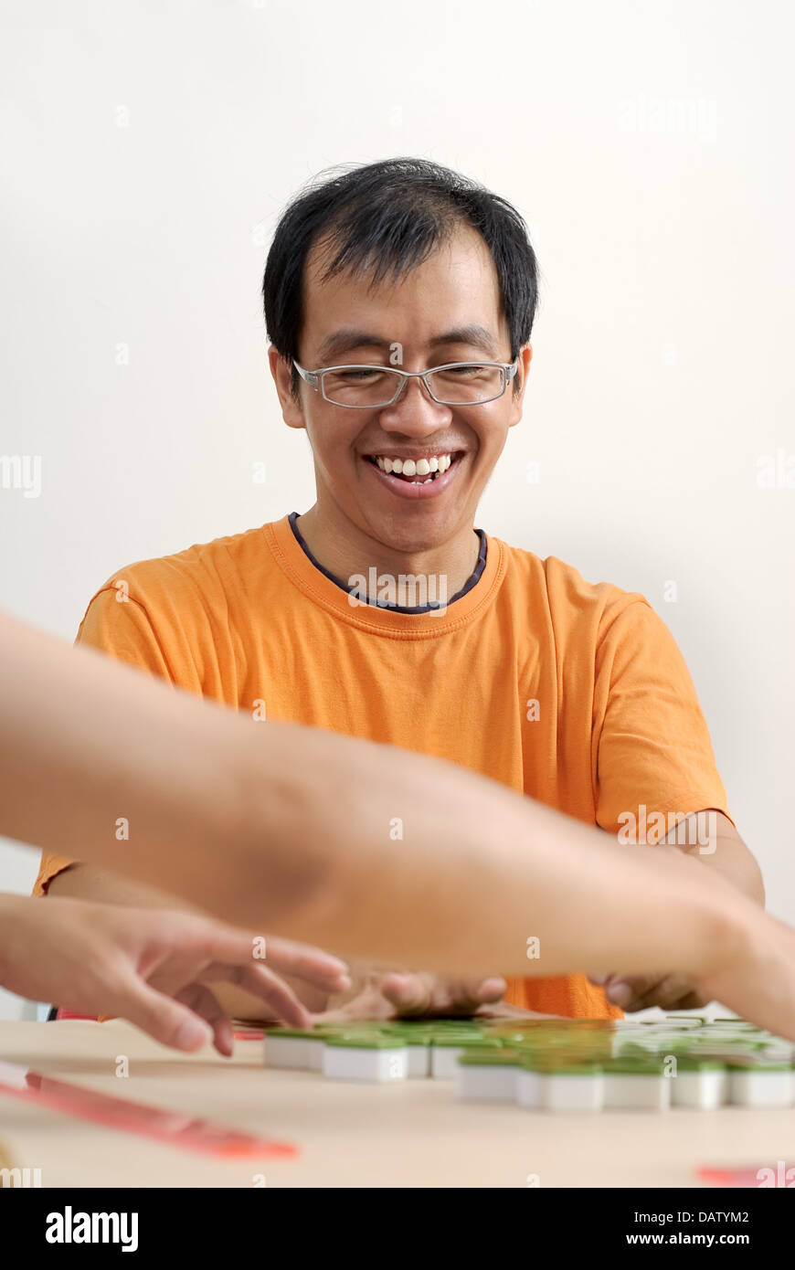 Happy smiling Asian man play Mahjong Stock Photo - Alamy
