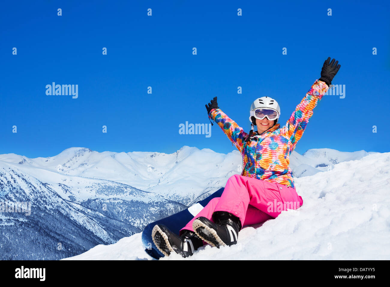 Happy excited woman in pink sit on snow holding snowboard with lifted ...