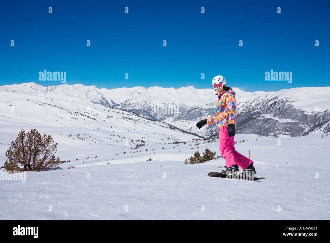 Cute happy young woman on snow sliding downhill the mountain on ski ...