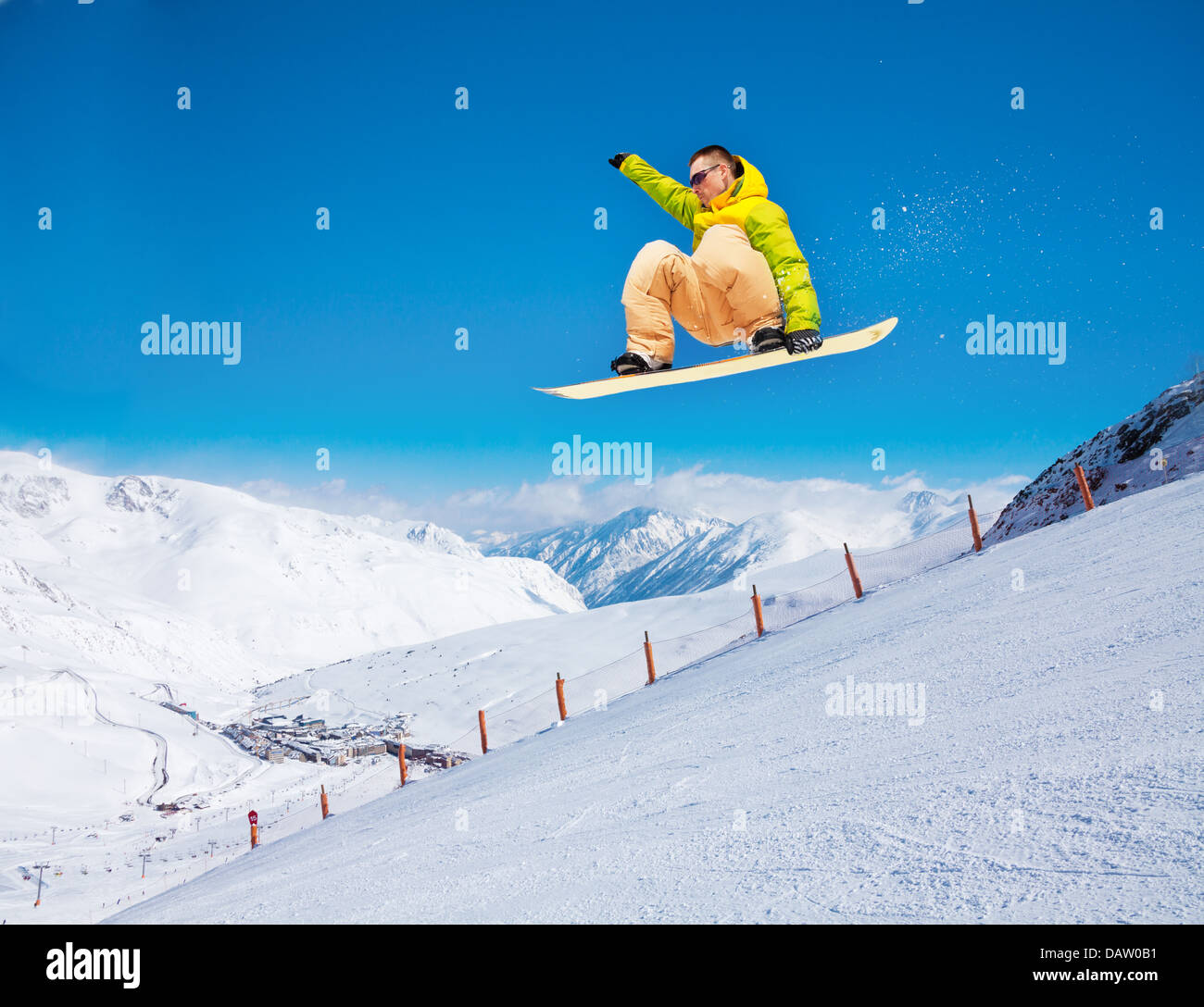 Cute handsome snowboarder man holding snowboard in the air jumping in ...