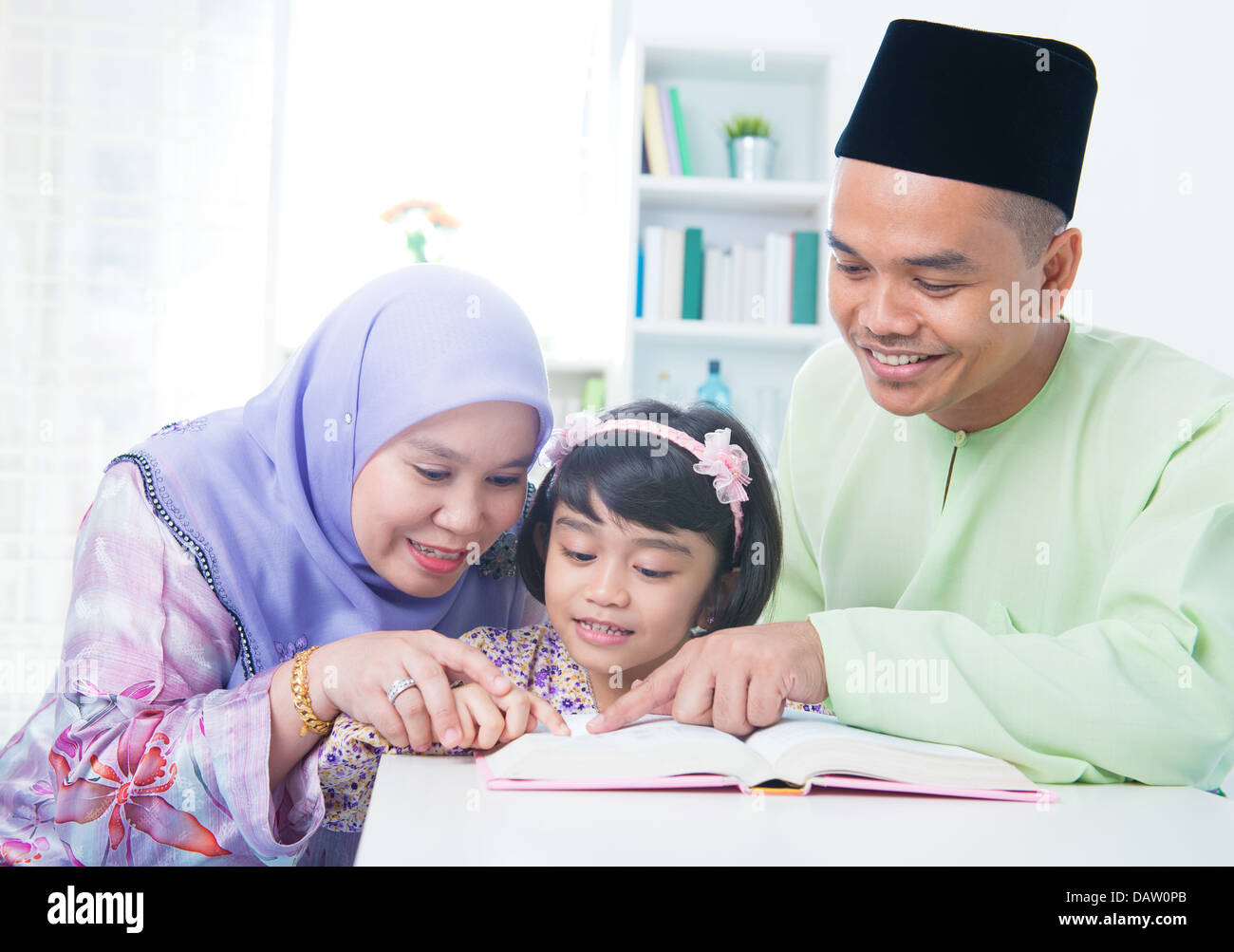 Muslim family reading book Stock Photo - Alamy