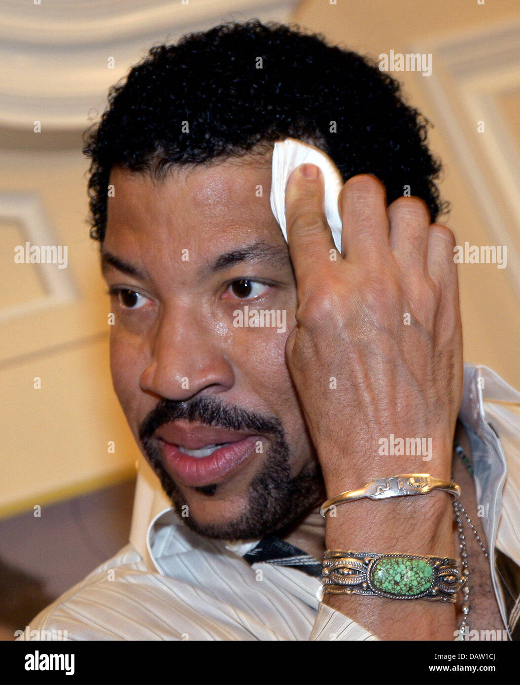 US-American singer Lionel Richie wipes sweat from his face prior to the ...