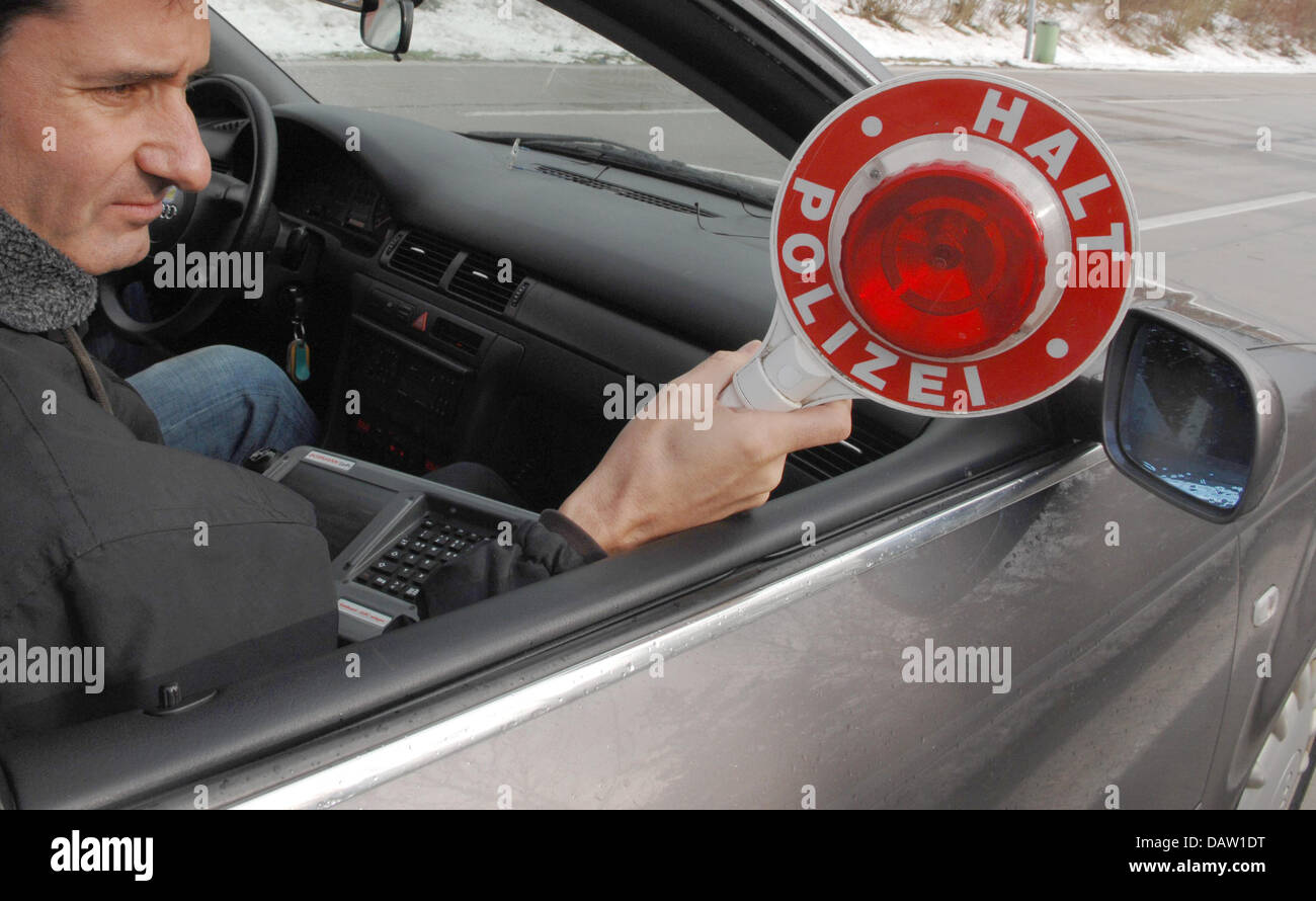 A police officer sticks the signalling disc out of a civil patrol ...