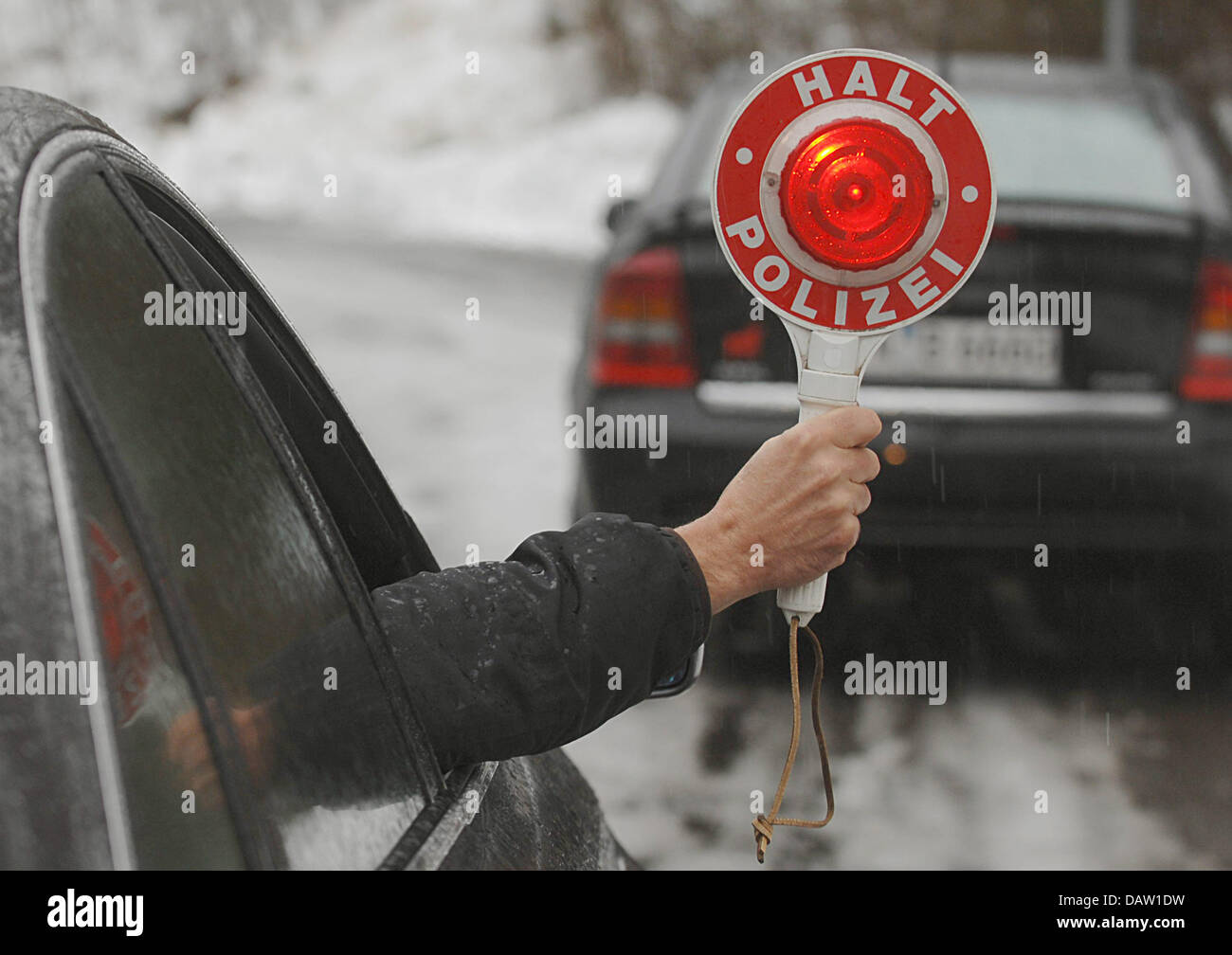 A police officer sticks the signalling disc out of a civil patrol ...
