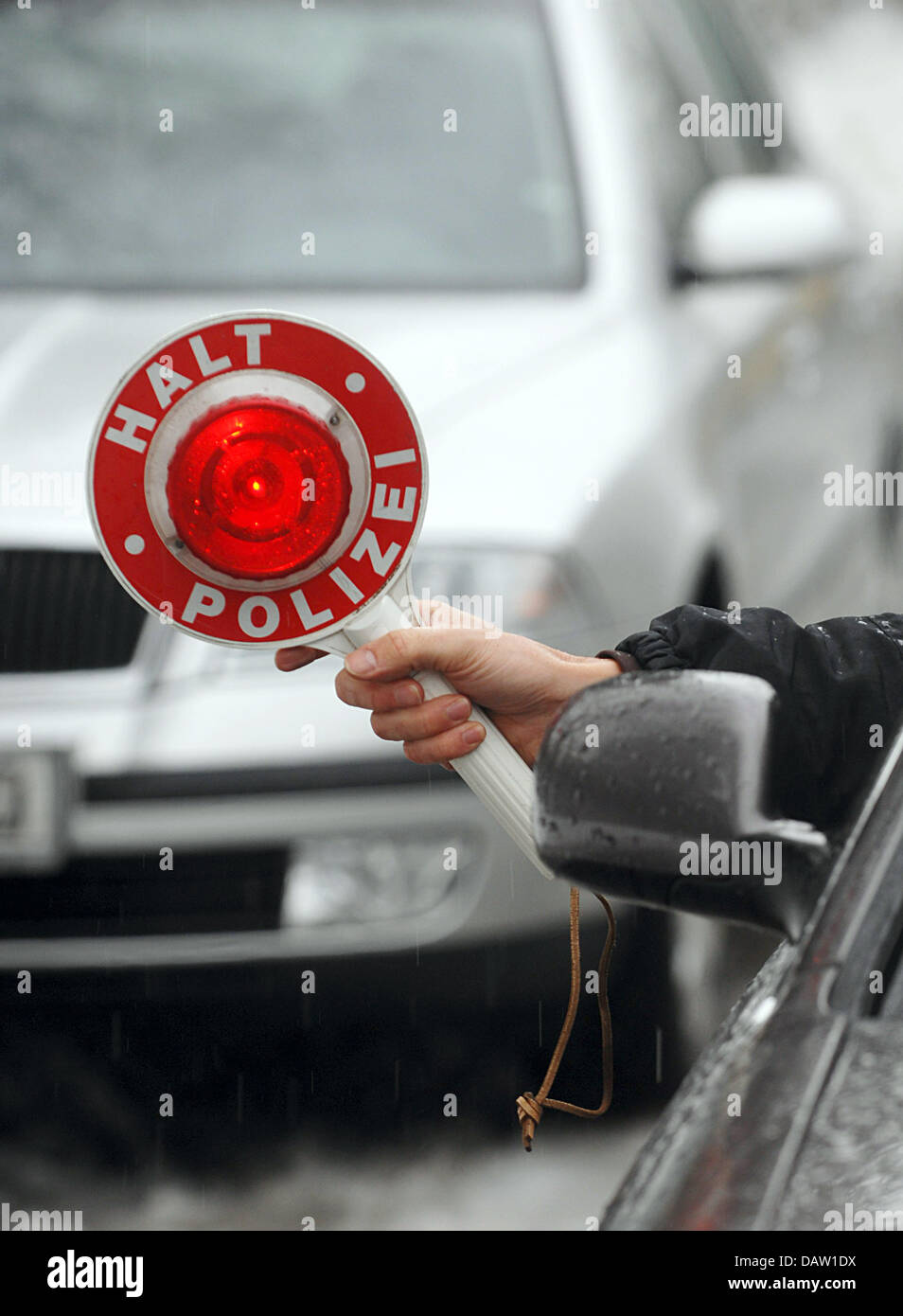 A police officer sticks the signalling disc out of a civil patrol ...